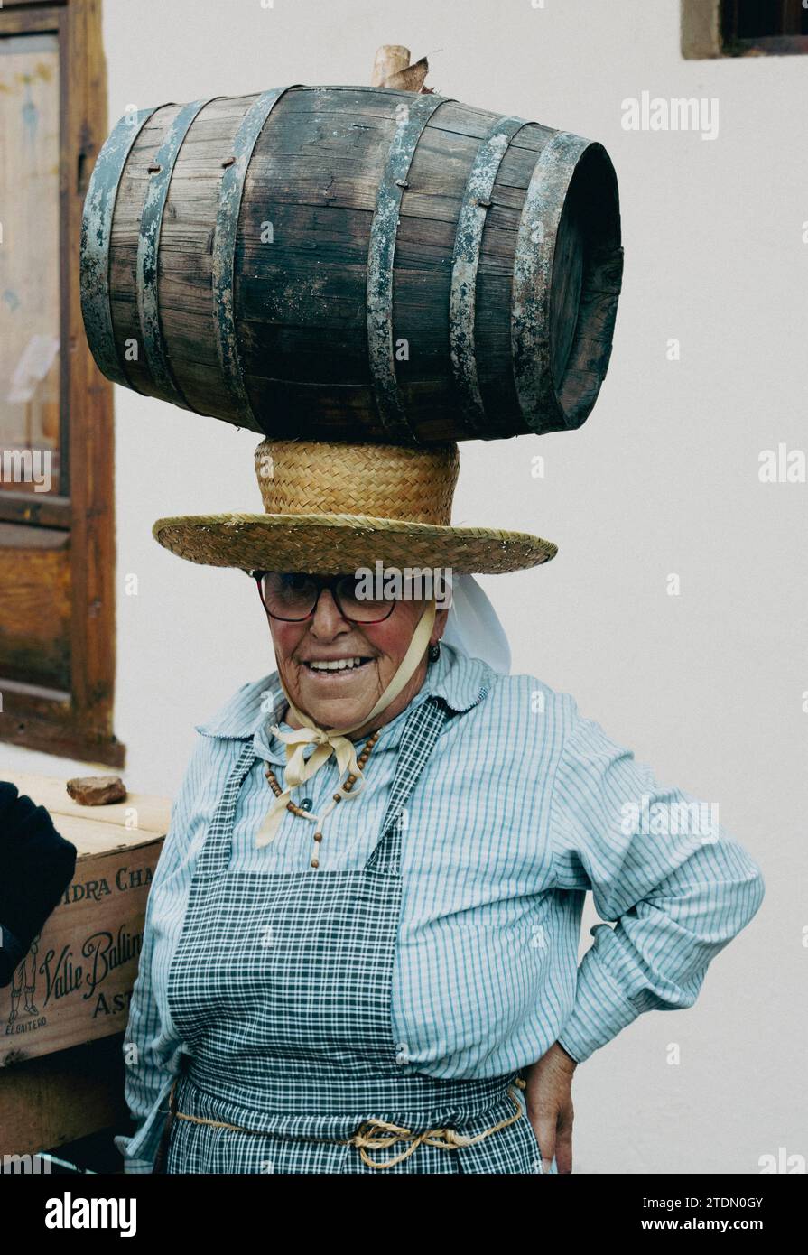 Photo of a lady with a loaded wine barrel on her head, on the day of ...