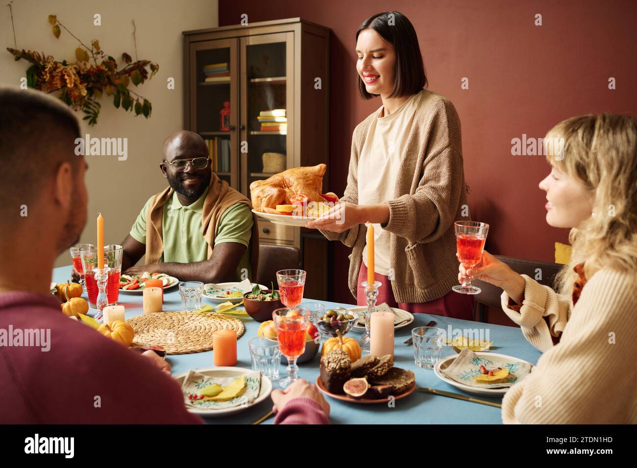 Thanksgiving dinner hostess serving traditional roasted turkey to her ...