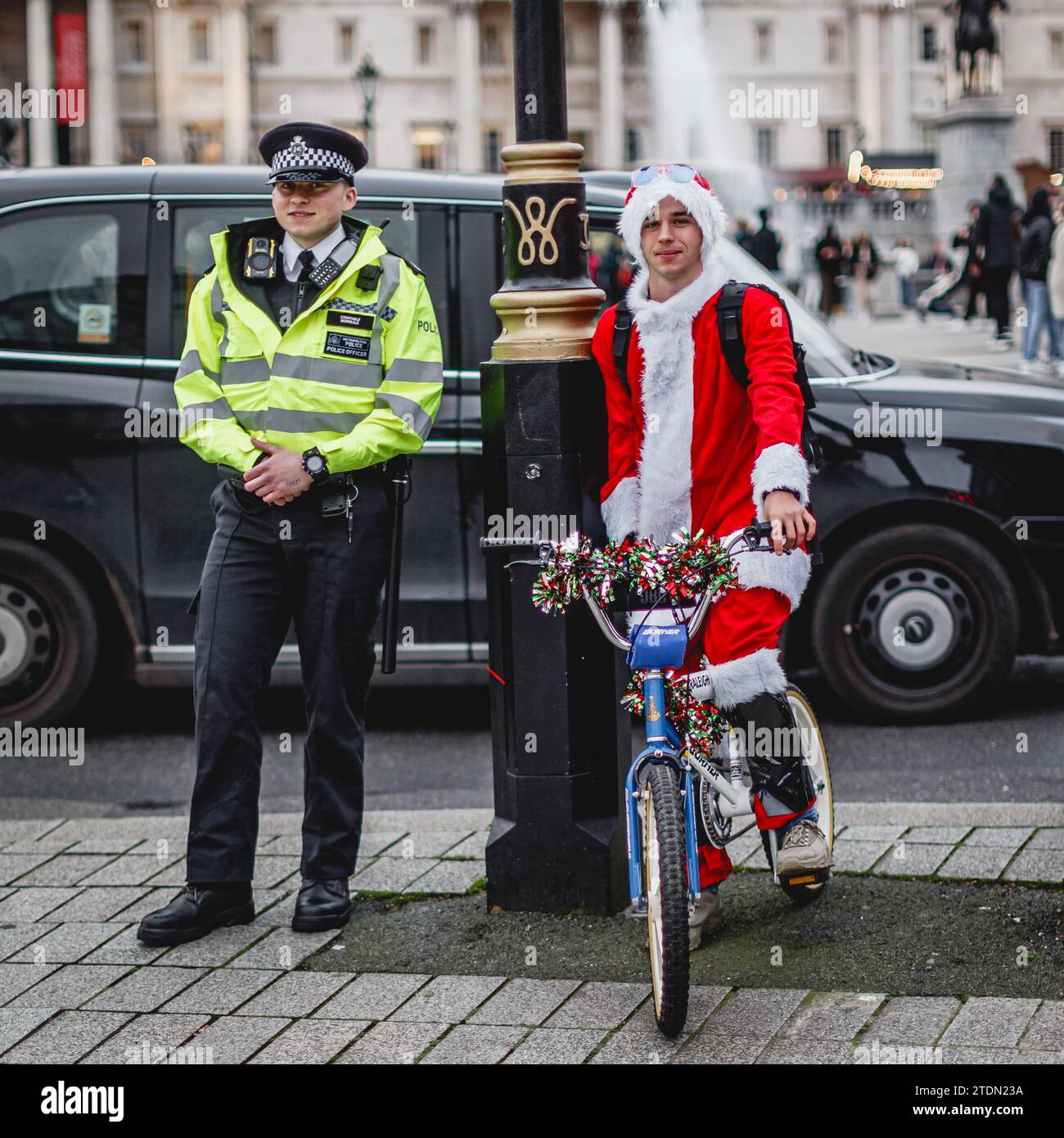A met police officer and a father christmas on a bicycle in London ...
