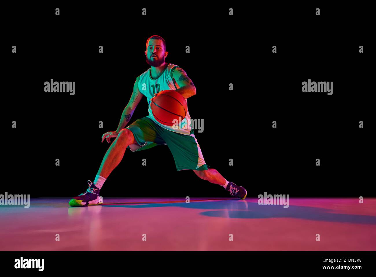 Full-length portrait of basketball player training dribbling technique ...