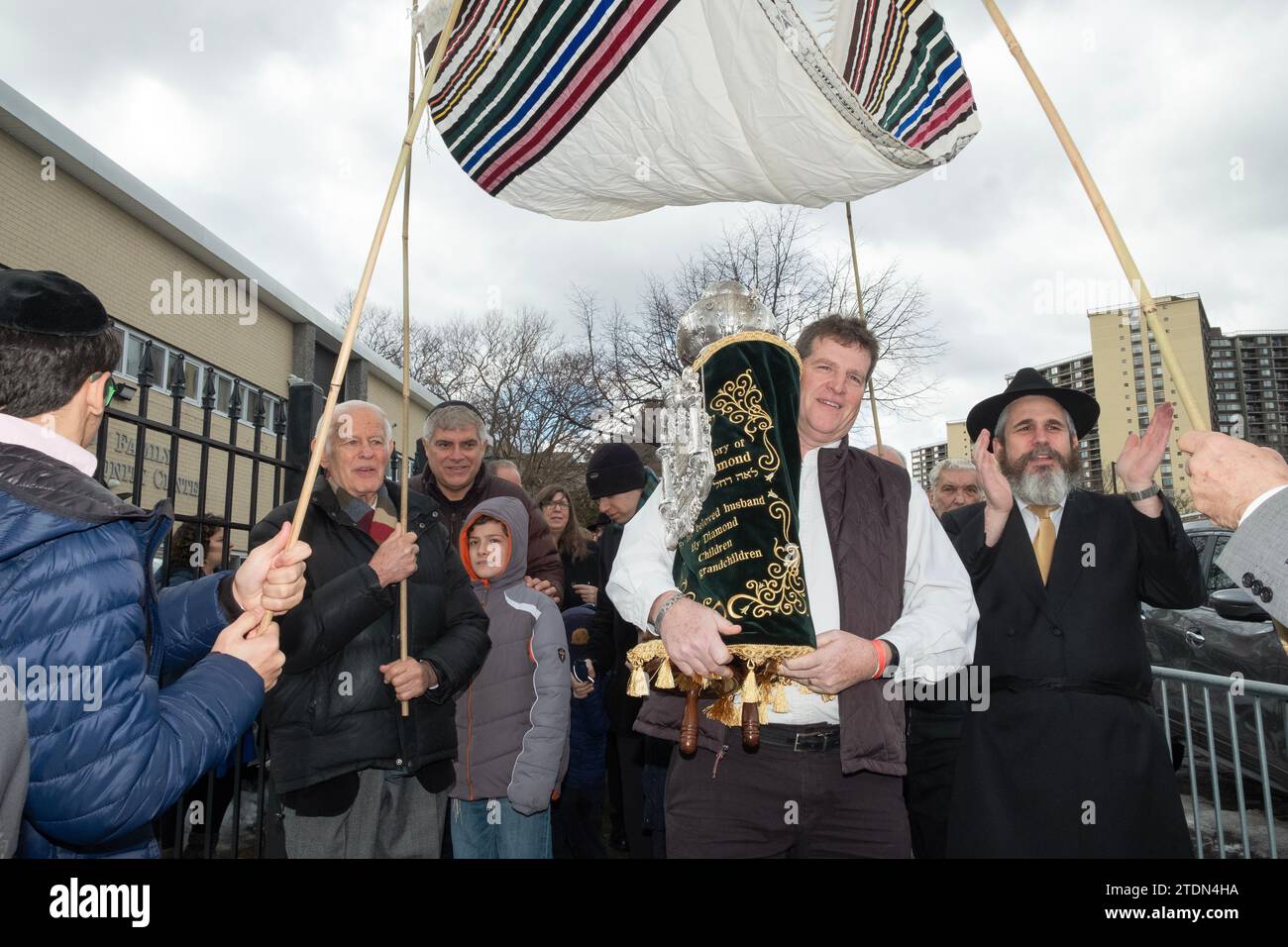 A newly written Torah is paraded under a canopy to the temple where it ...