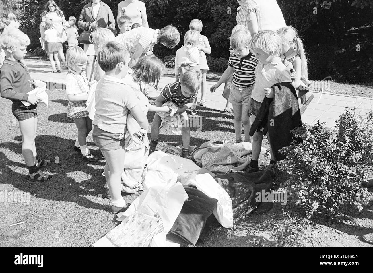 A group of children plays with rags and rugs outside, 08-09-1971 ...