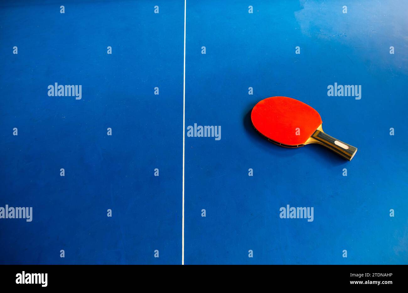 Table tennis red racket and blue table Stock Photo - Alamy