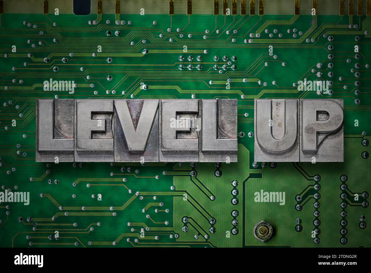 level up phrase made from metallic letterpress blocks on the green pc ...