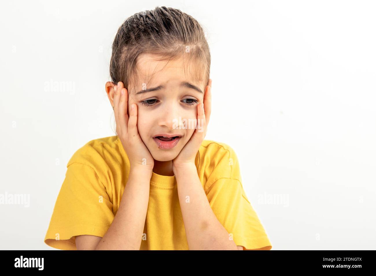 Little desperate girl looking panic, holding her head with both hands ...