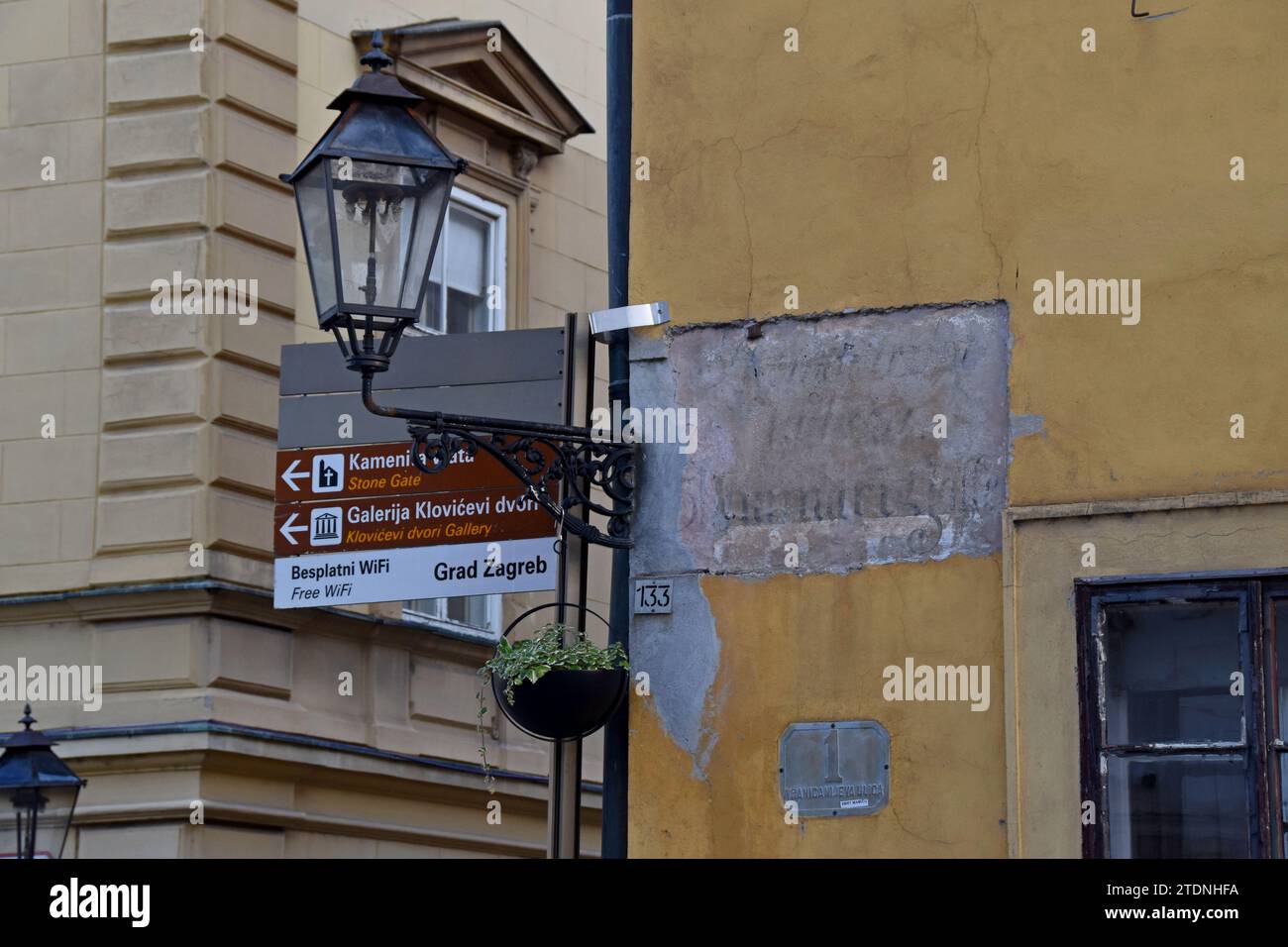 Tourist street direction signs and a ghost sign on the wall in the old ...