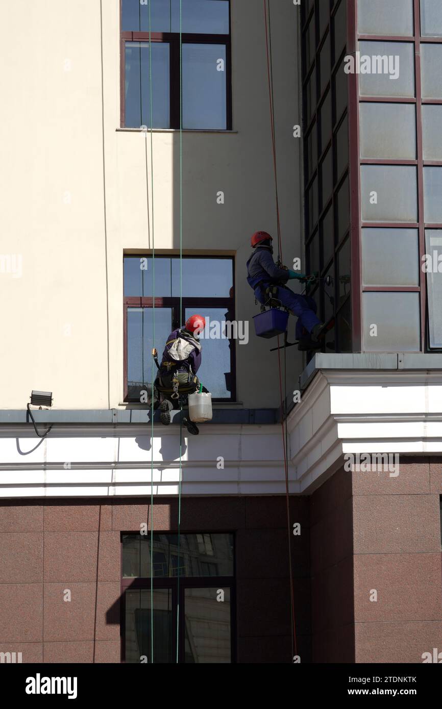 Industrial climbers in protection outfit cleaning window glass on the ...