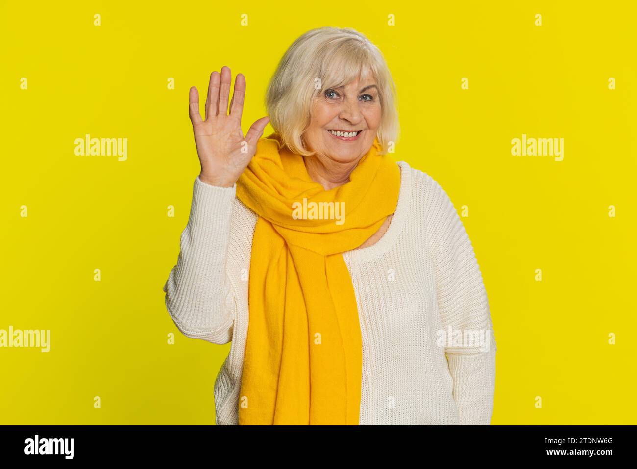 Old senior woman smiling friendly at camera waving hands gesturing ...