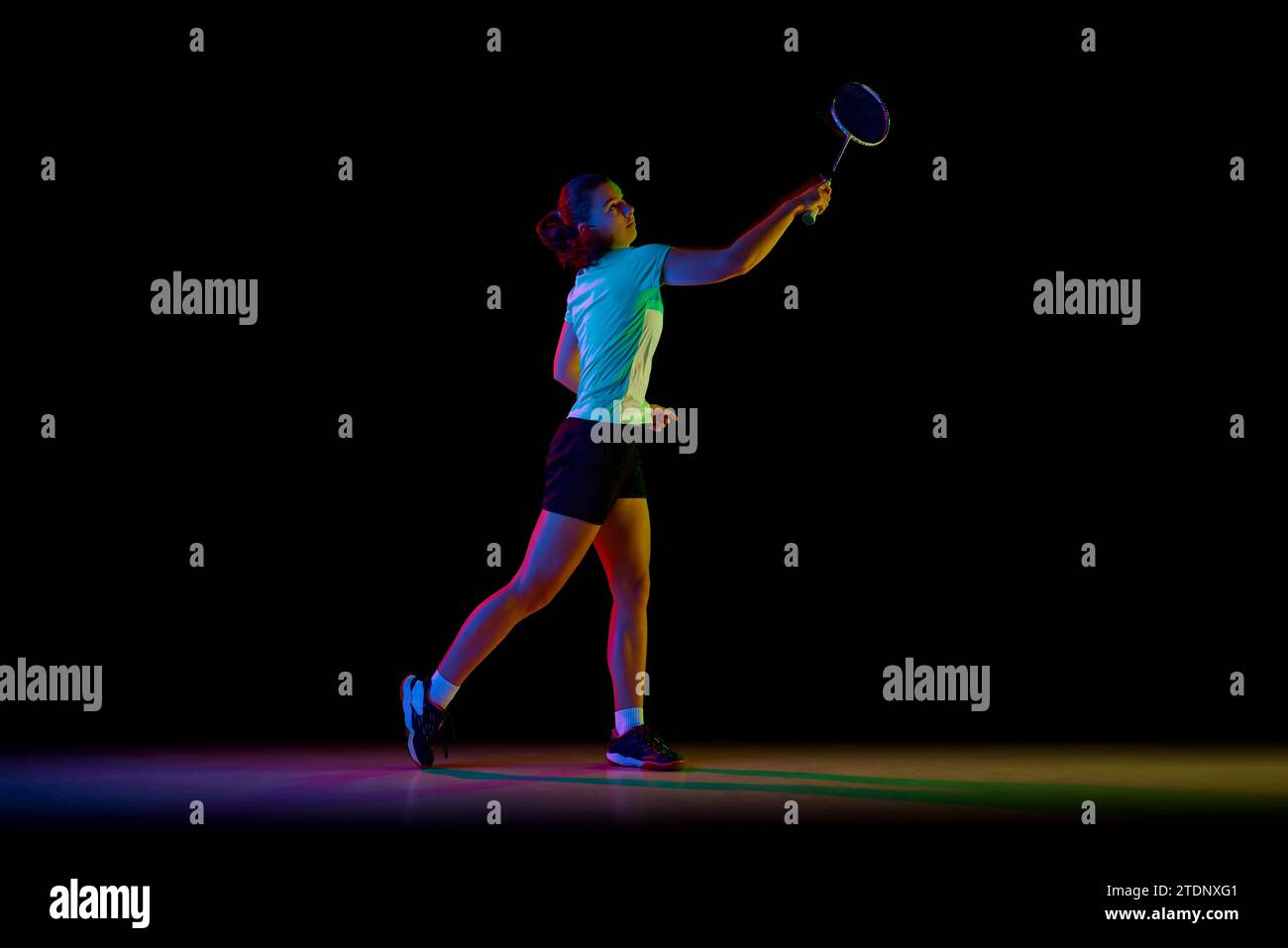 Full length portrait of skilled female badminton player in motion ...