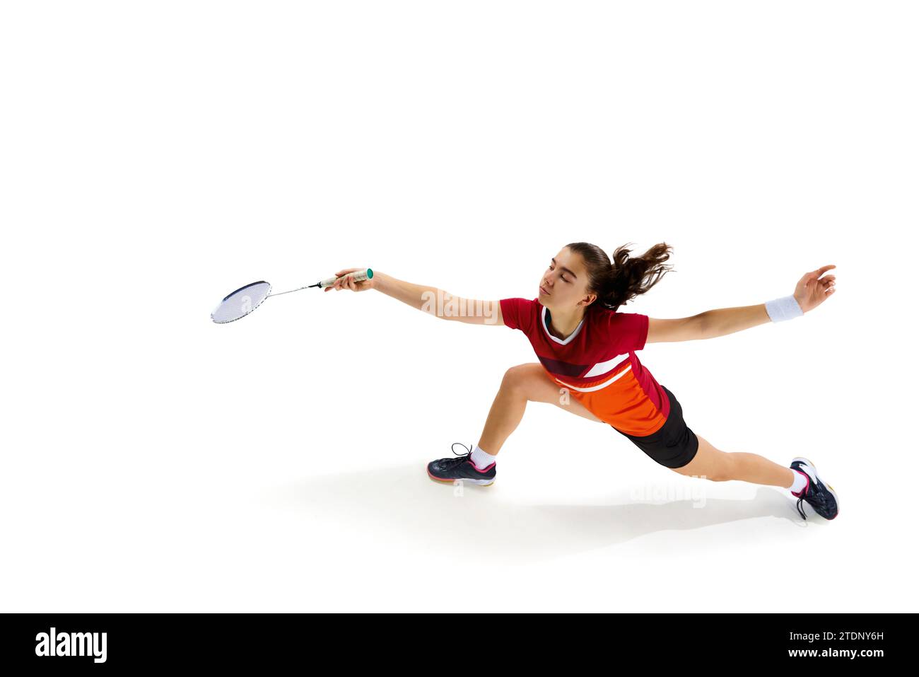 Dynamic portrait of professional female badminton player engaged in ...