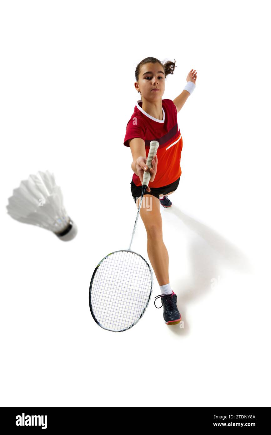 Full length portrait of badminton athlete in dynamic pose, training rigorously against white ...