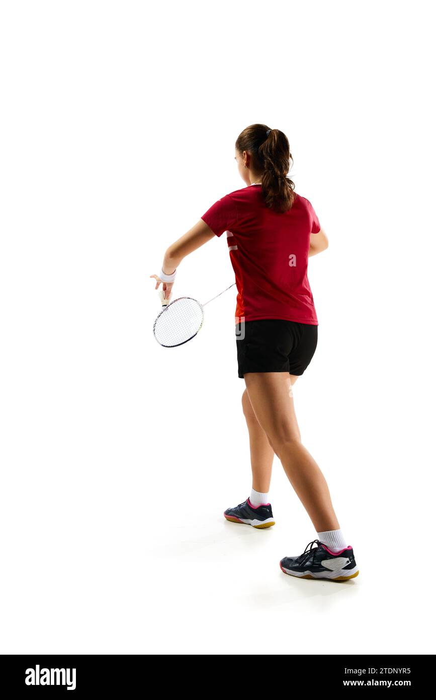 Rear view portrait of young girl, skilled badminton player practicing ...