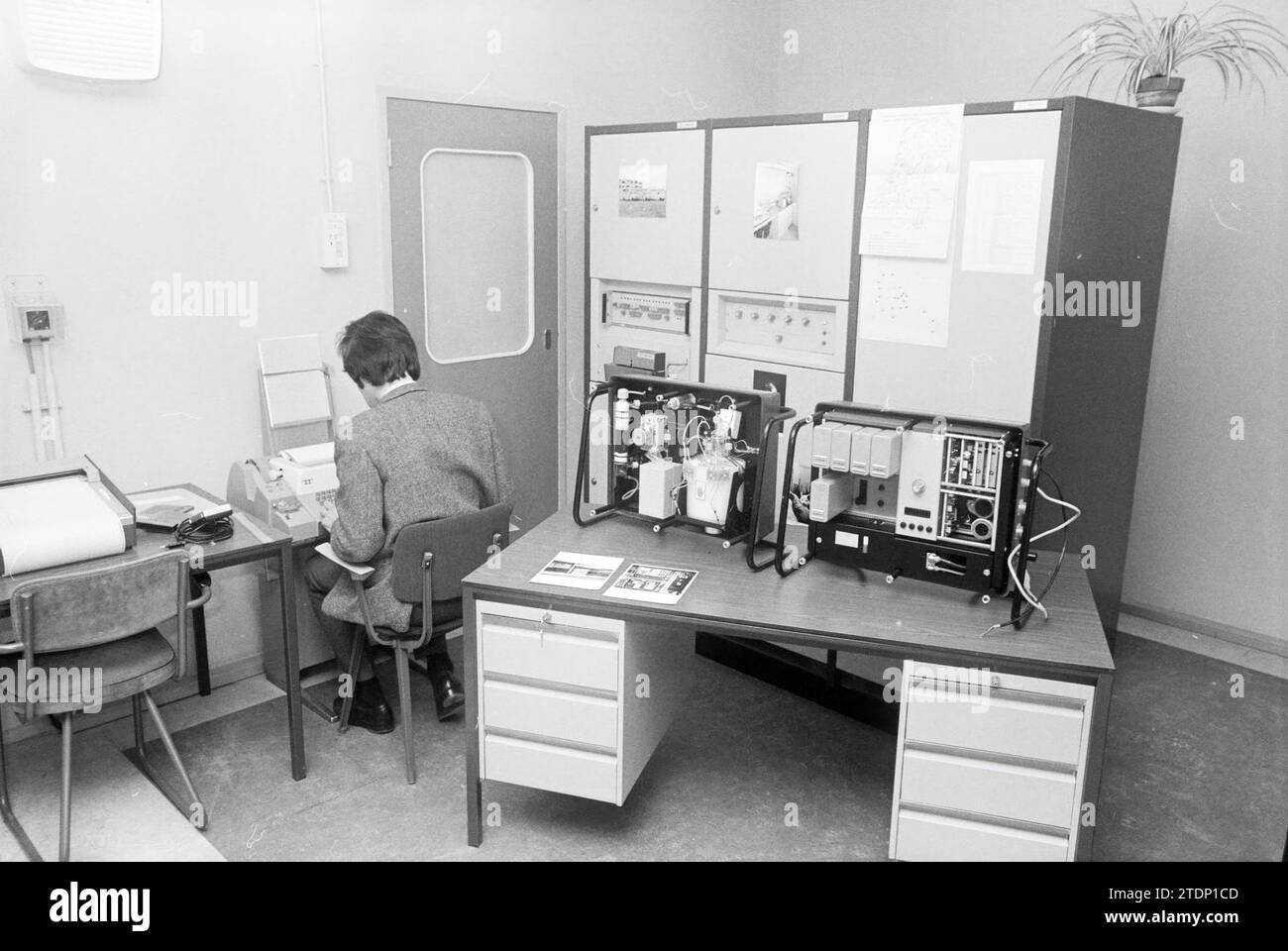 Man behind telex and measuring instruments. Report storm damage ...