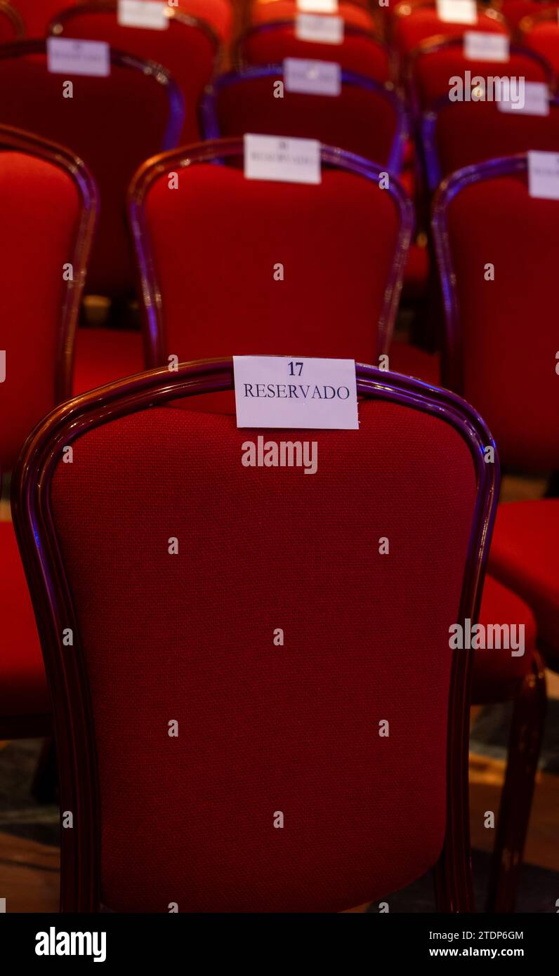 Reserved red velvet chairs in an auditorium, awaiting an audience ...