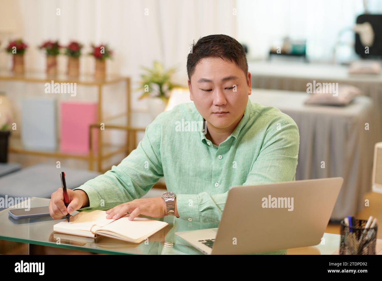 Spa salon manager checking messages from clients and writing notes in ...