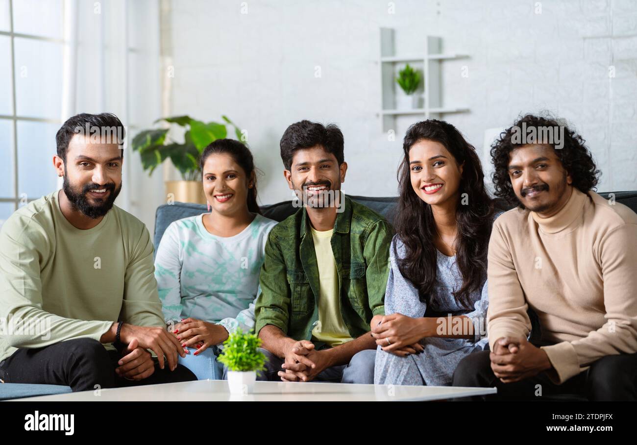 Group of relaxed friends watching movie on tv or television at home ...