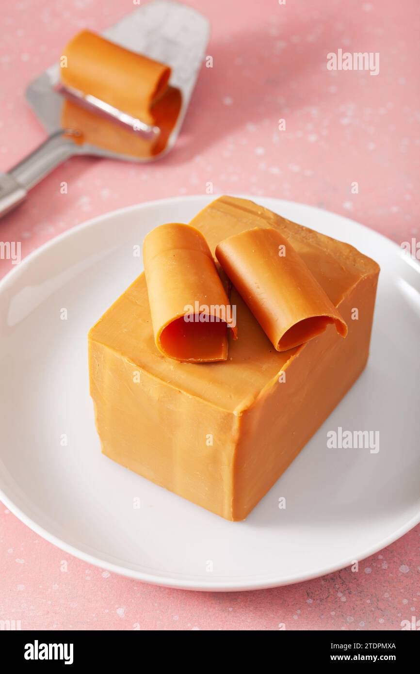 Norwegian brunost traditional brown cheese block and slicer Stock Photo ...