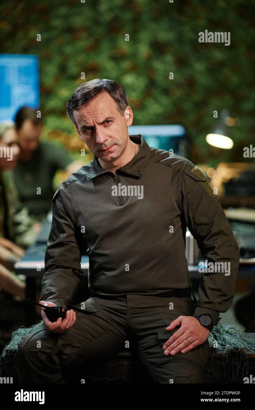 Strict mature male officer of surveillance department with walkie ...