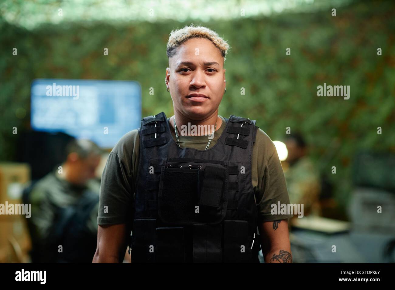 Young multiethnic female officer in black bulletproof vest over upper ...