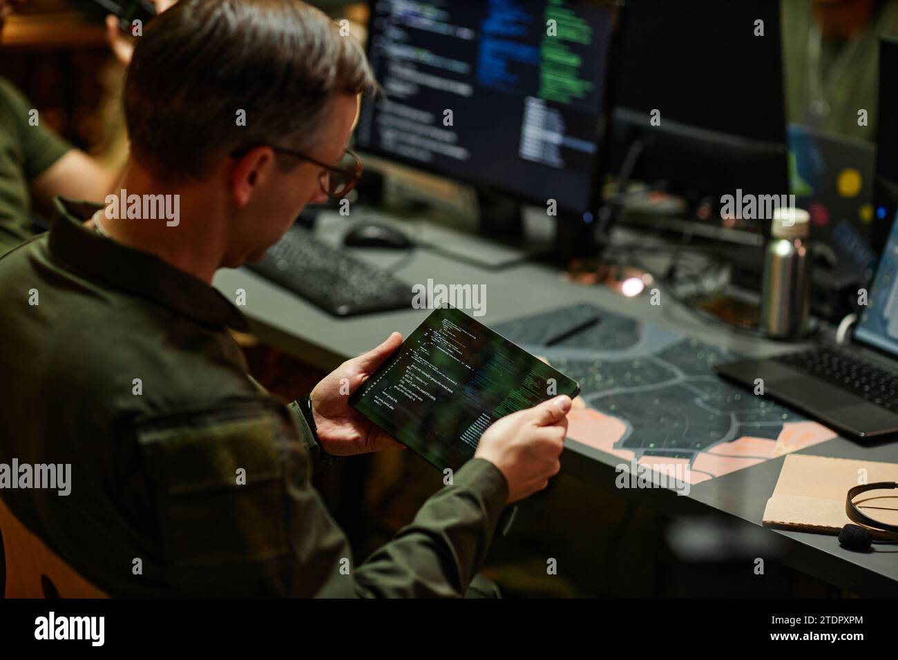 Young male military officer looking at screen of tablet in his hands ...