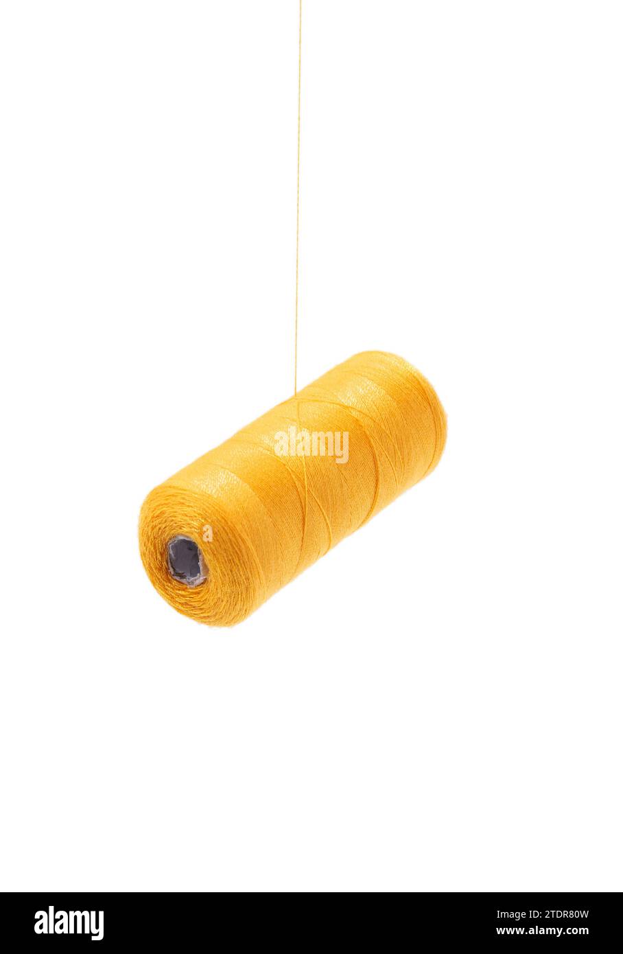 spools of yellow color sewing cotton floating Stock Photo - Alamy