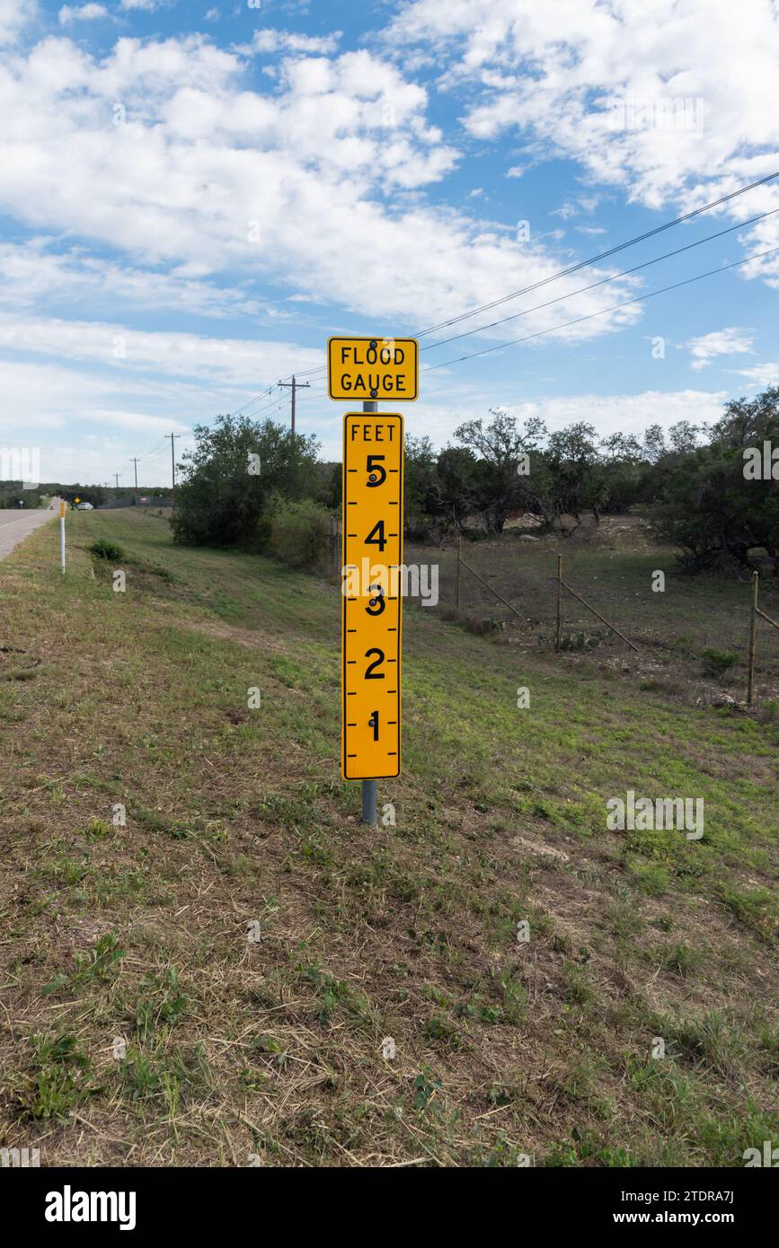 Yellow sign shaped like a ruler, a flood gauge by the side of a highway ...