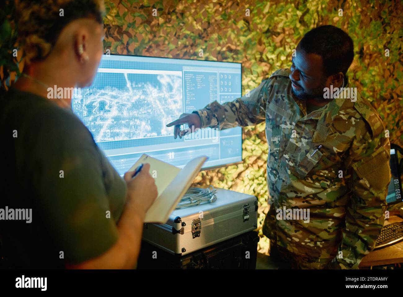 Young African American officer pointing at computer screen while ...