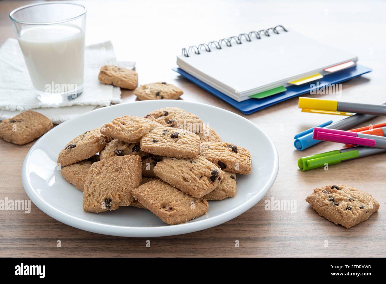 A child's tea party with biscuits, felt-tip pens and a school homework ...