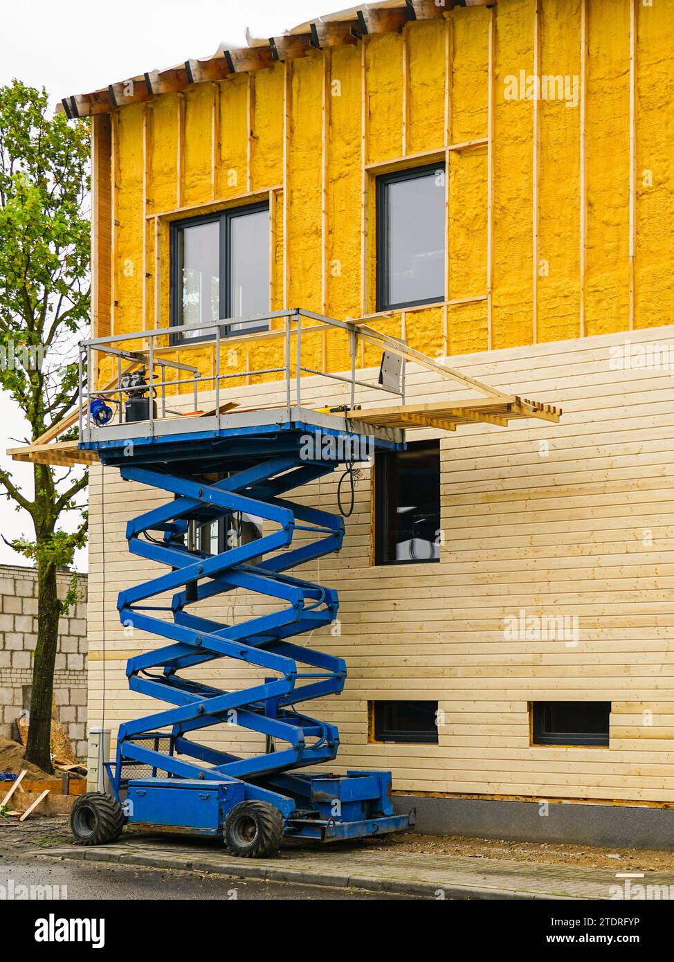 Facade cladding works with wooden planks after facade spraying with ...