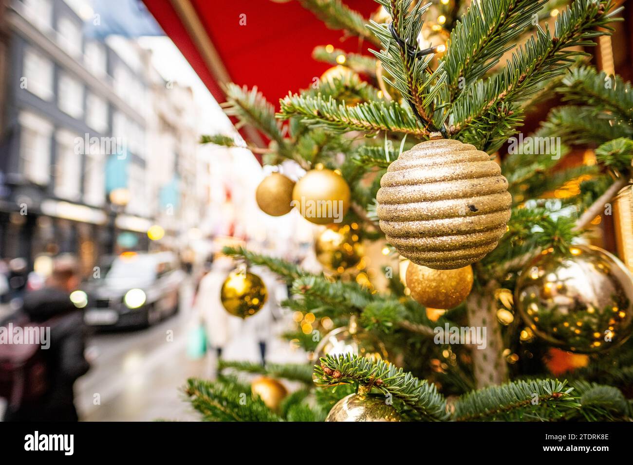 Close focus of Christmas decorations on busy city shopping street scene ...