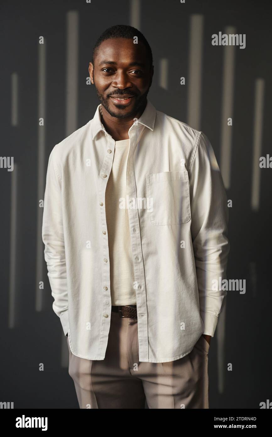 Vertical portrait of charismatic Black man smiling at camera standing ...