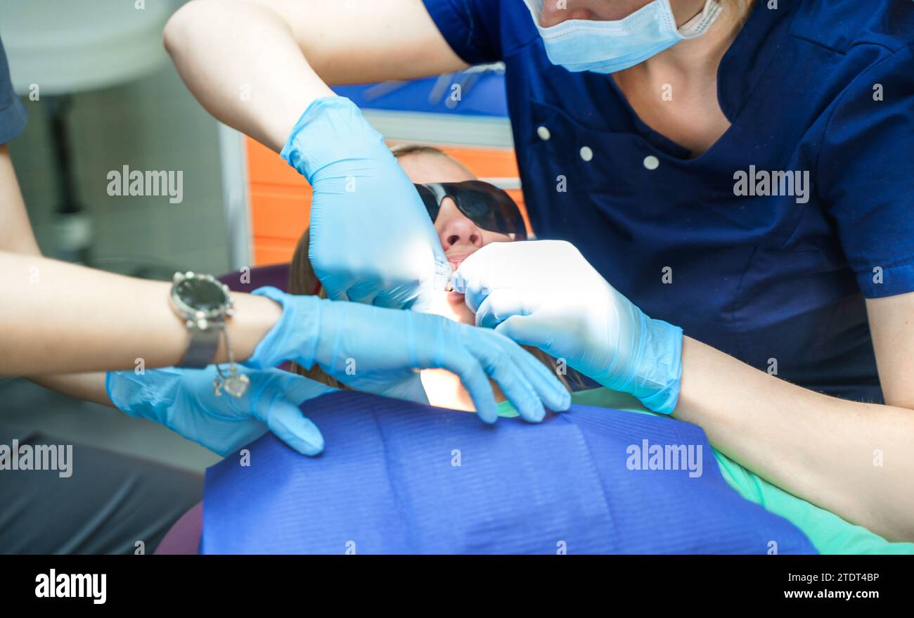 Little scared girl sitting in chair in dentist doctor office ...