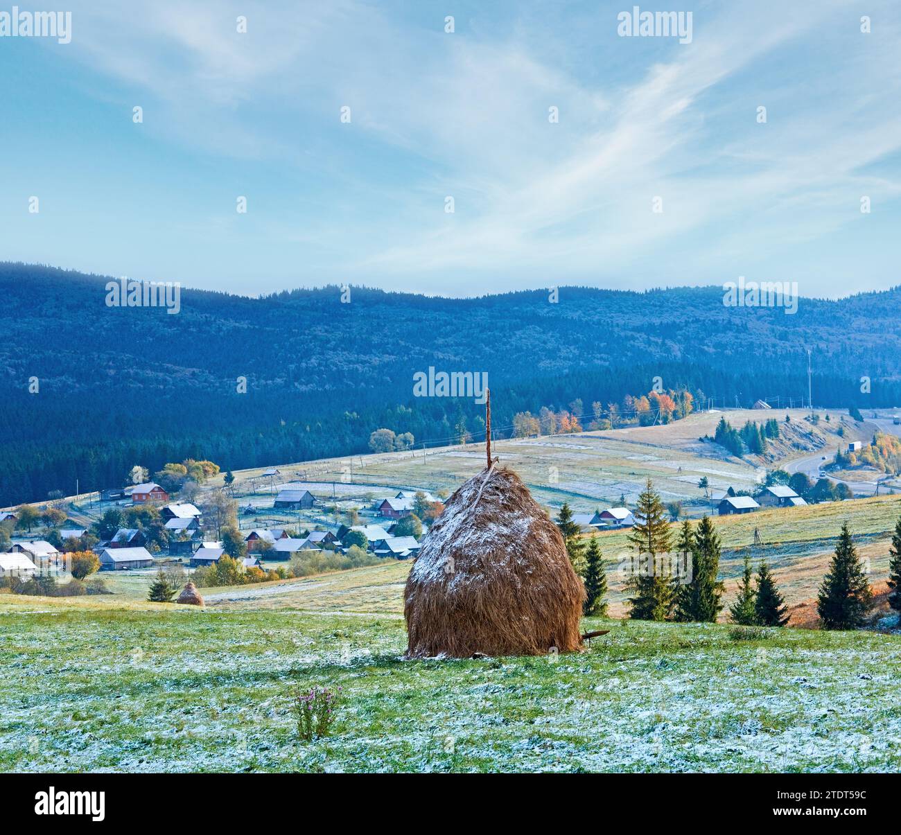First winter snow on October Carpathian mountain plateau with village ...