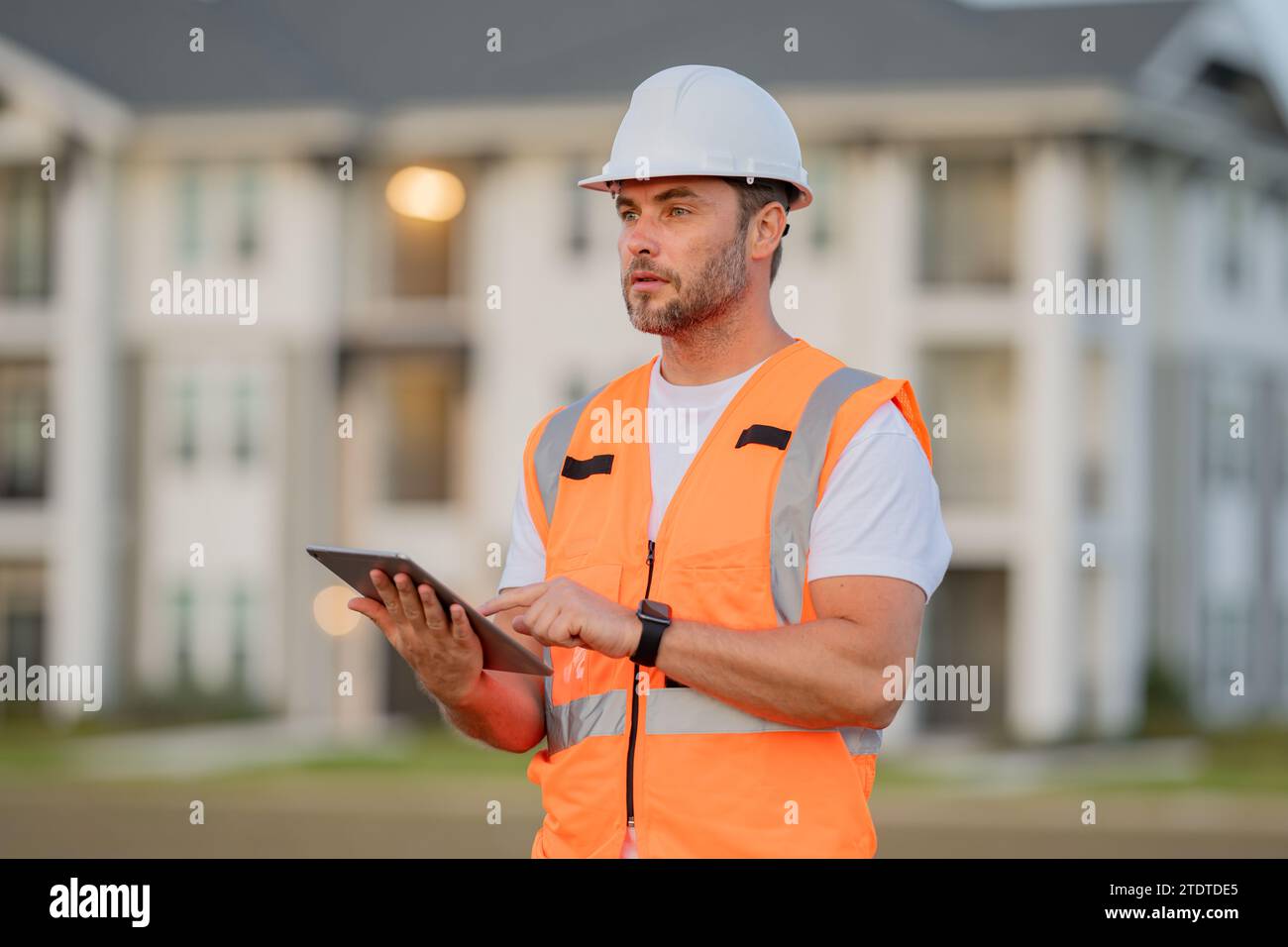 Engineer with tablet, building inspection. Construction man in helmet ...