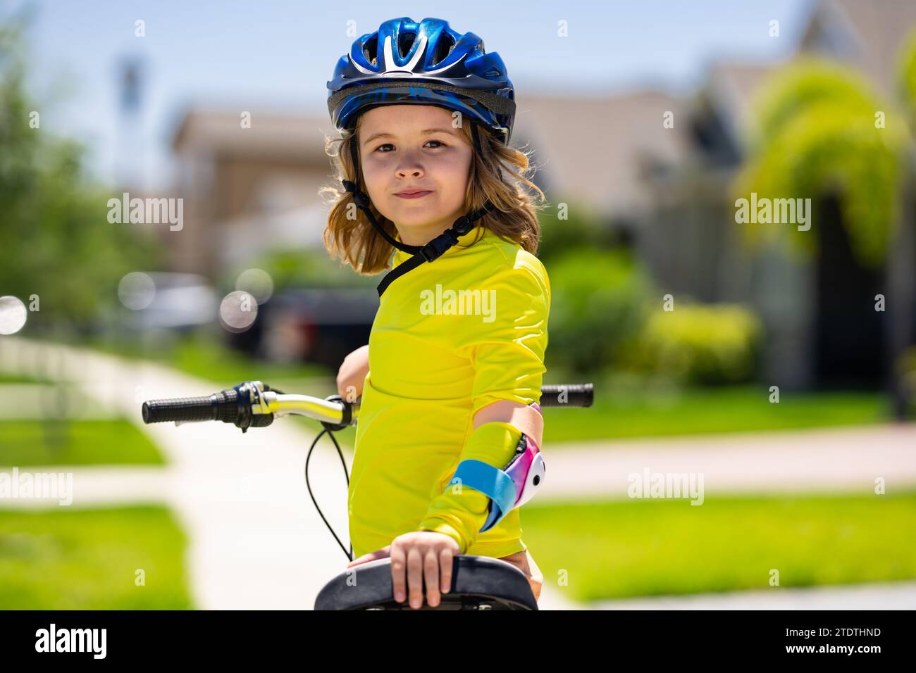 Child riding bicycle. Little kid boy in helmet on bicycle along bikeway ...