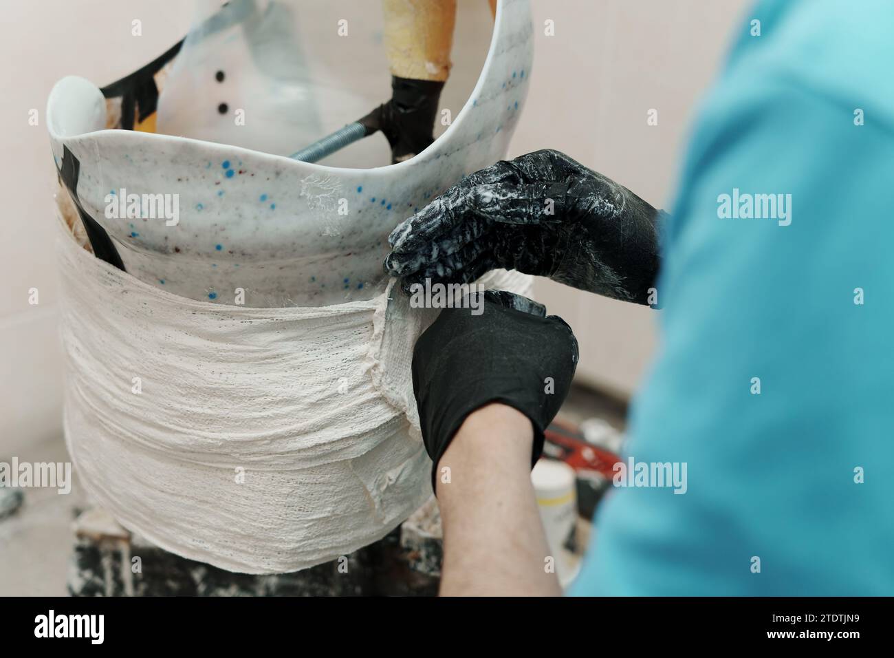 Male worker in black rubber gloves making hip disarticulation ...