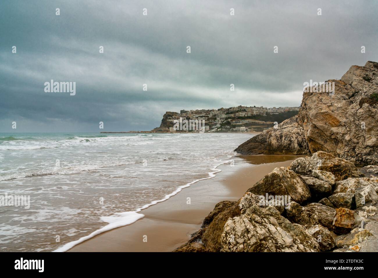 view of Peschici Bay and clifftop town under a rainy and overcast sky ...