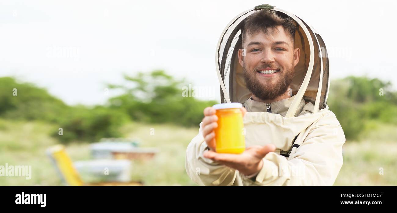 Beekeeper with honey in jar at apiary. Banner for design Stock Photo ...