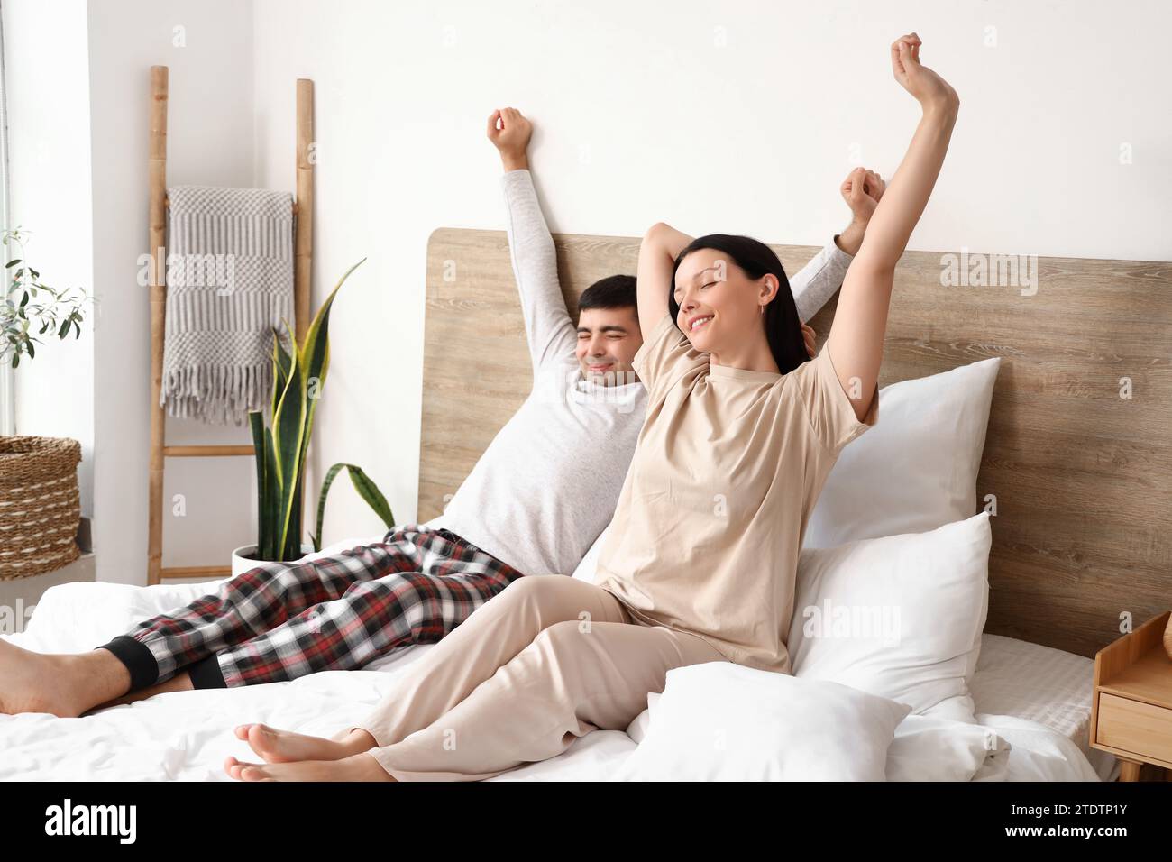 Young couple waking up in bedroom Stock Photo - Alamy