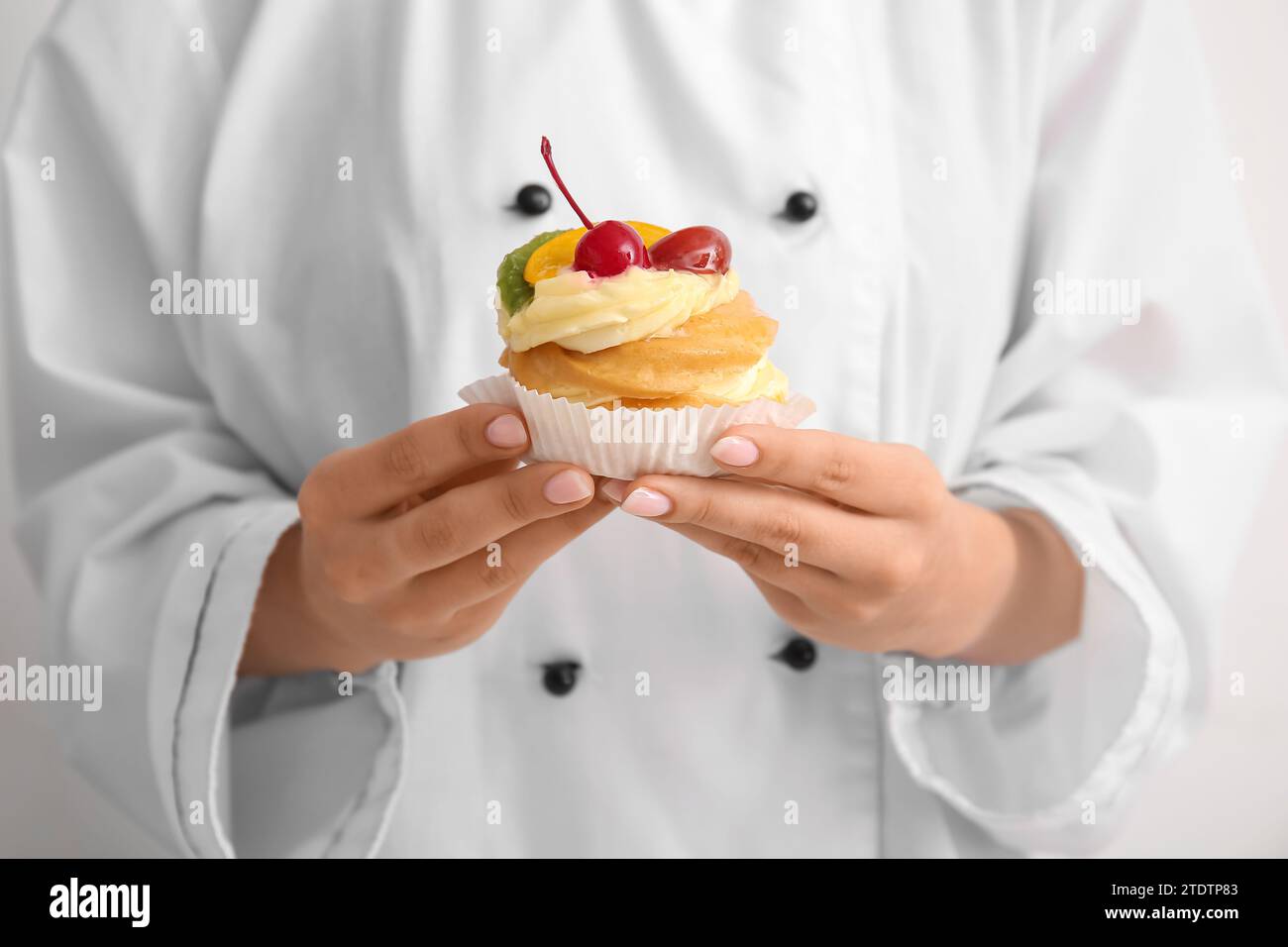 Female confectioner with tasty cake on white background Stock Photo - Alamy