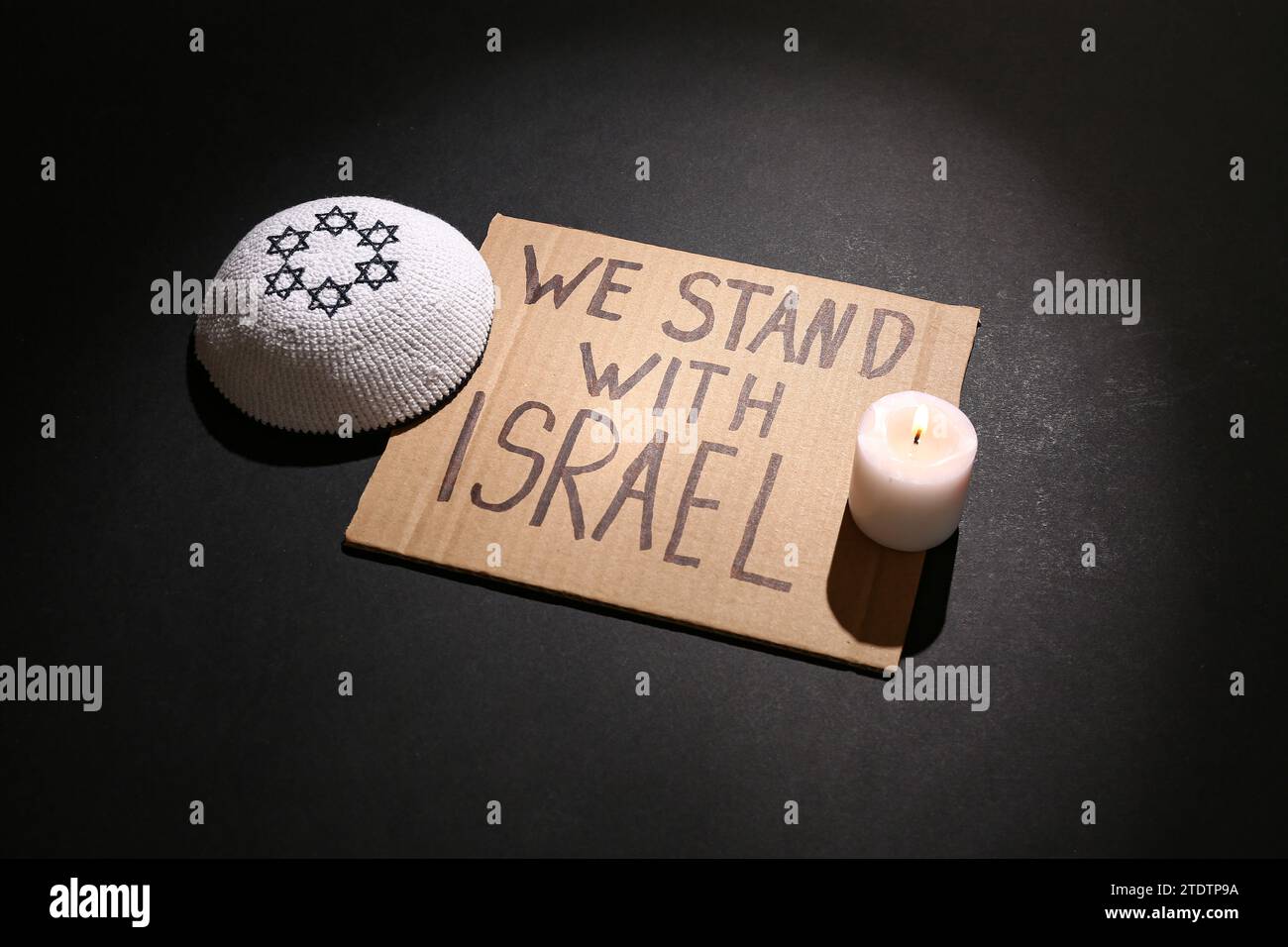 Text WE STAND WITH ISRAEL, Jewish hat and burning candle on dark ...