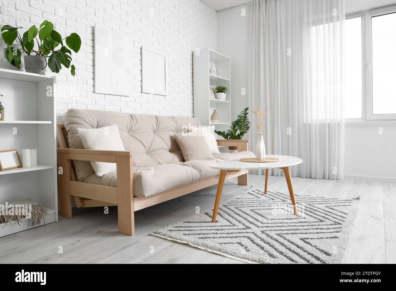 Interior of light living room with cozy sofa, houseplants and white ...