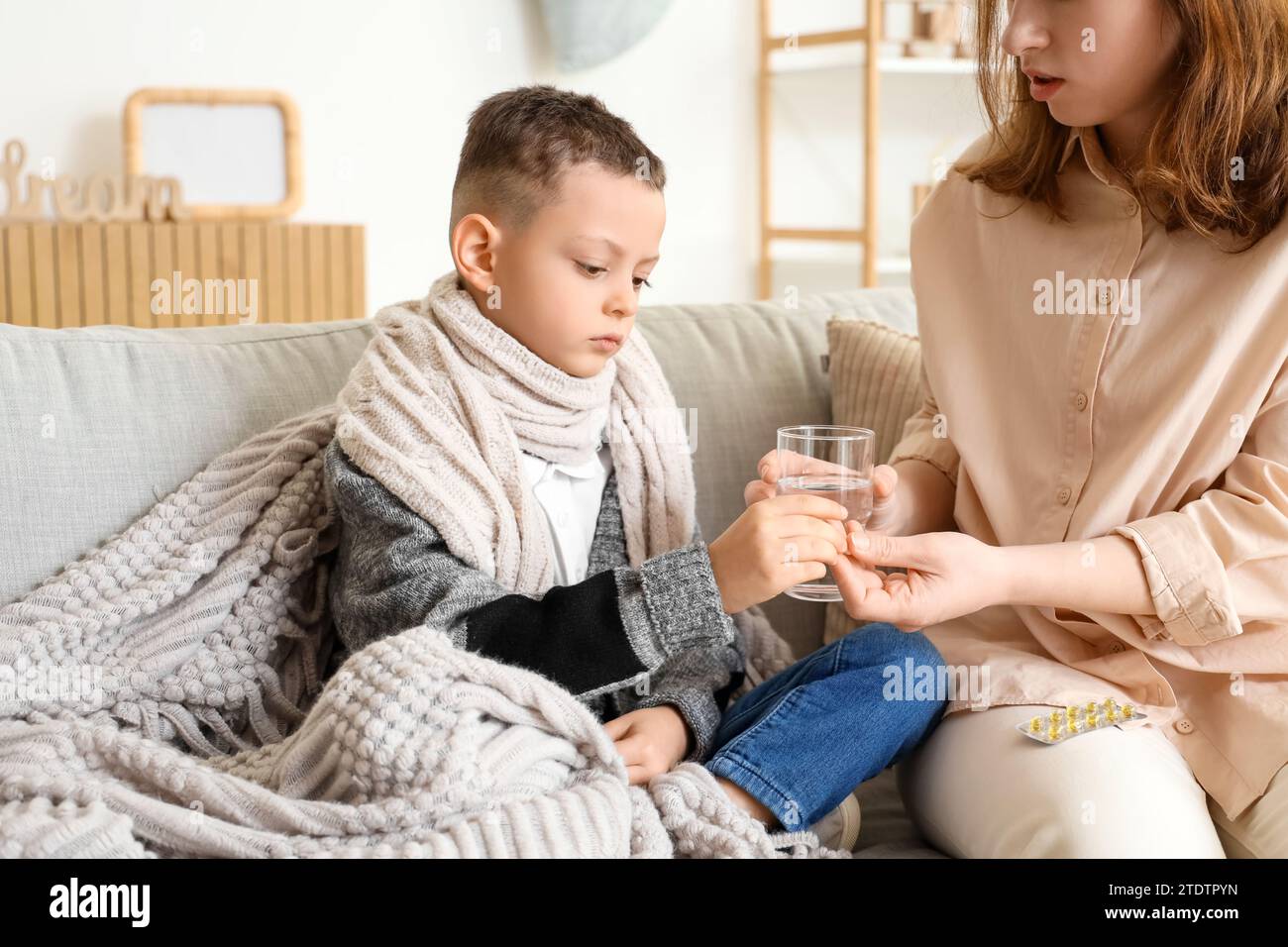 Ill little boy taking pill from his mother at home Stock Photo - Alamy