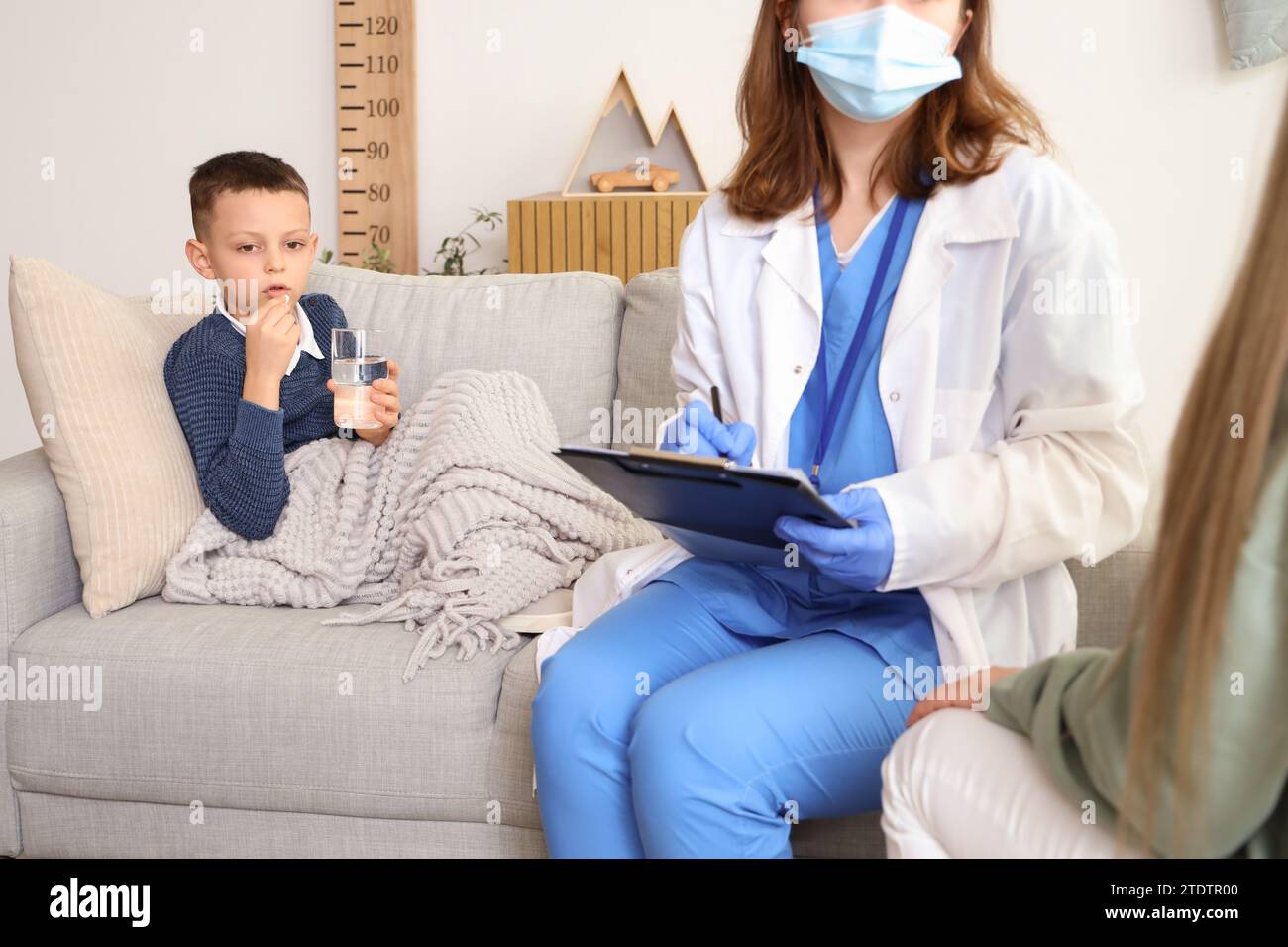 Ill little boy with doctor and his mother taking pill at home Stock ...