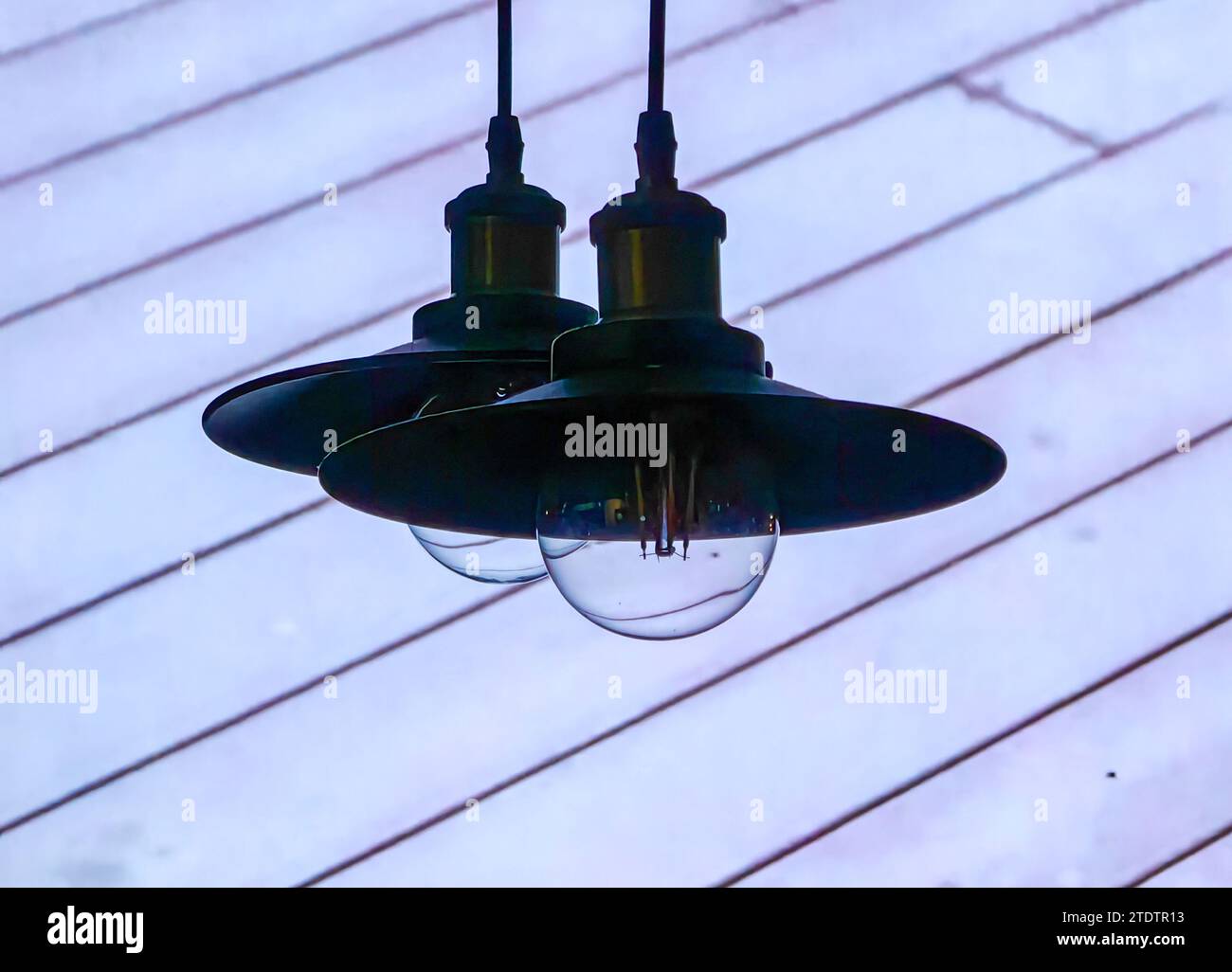 Electric elegance, chandeliers hanging against TV backdrop. Luminous ...