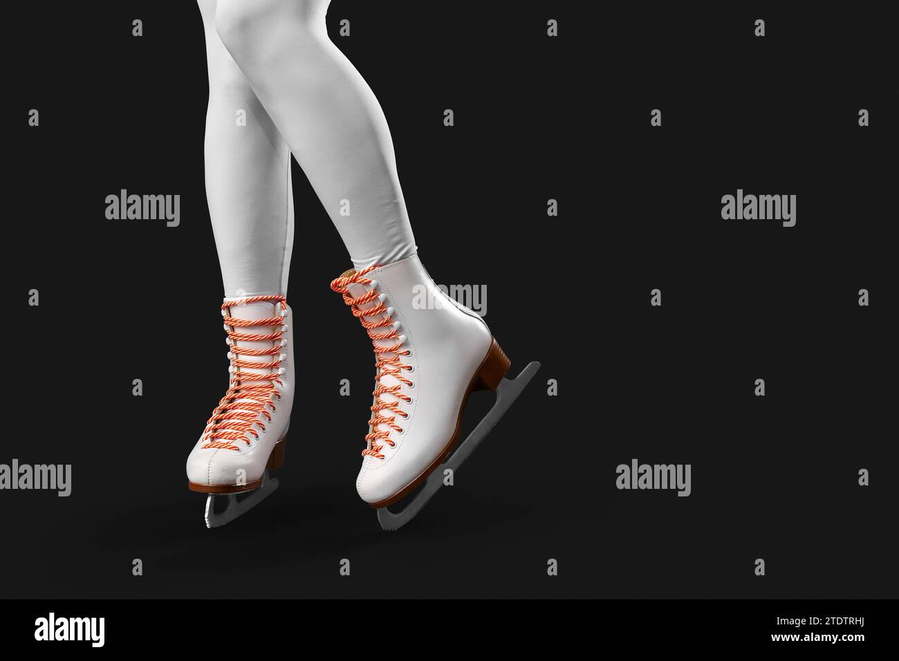 Legs of female figure skater in ice skates on black background Stock ...