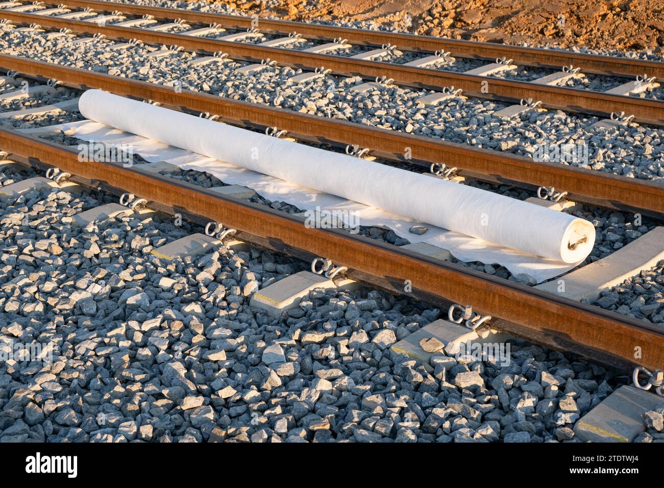A roll of geotextile is laid on new tracks for the tramway, layer of ...