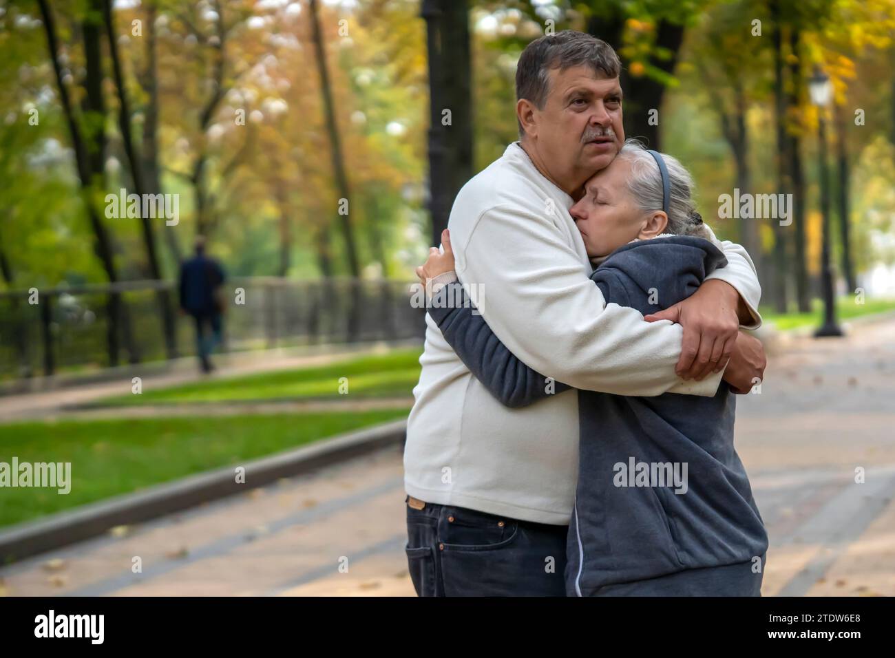 An elderly couple hugs in the park during the walk Stock Photo - Alamy