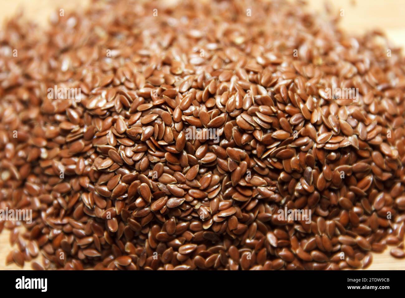 Lots of linen brown raw seeds made for cooking use. Top view. Focus in ...