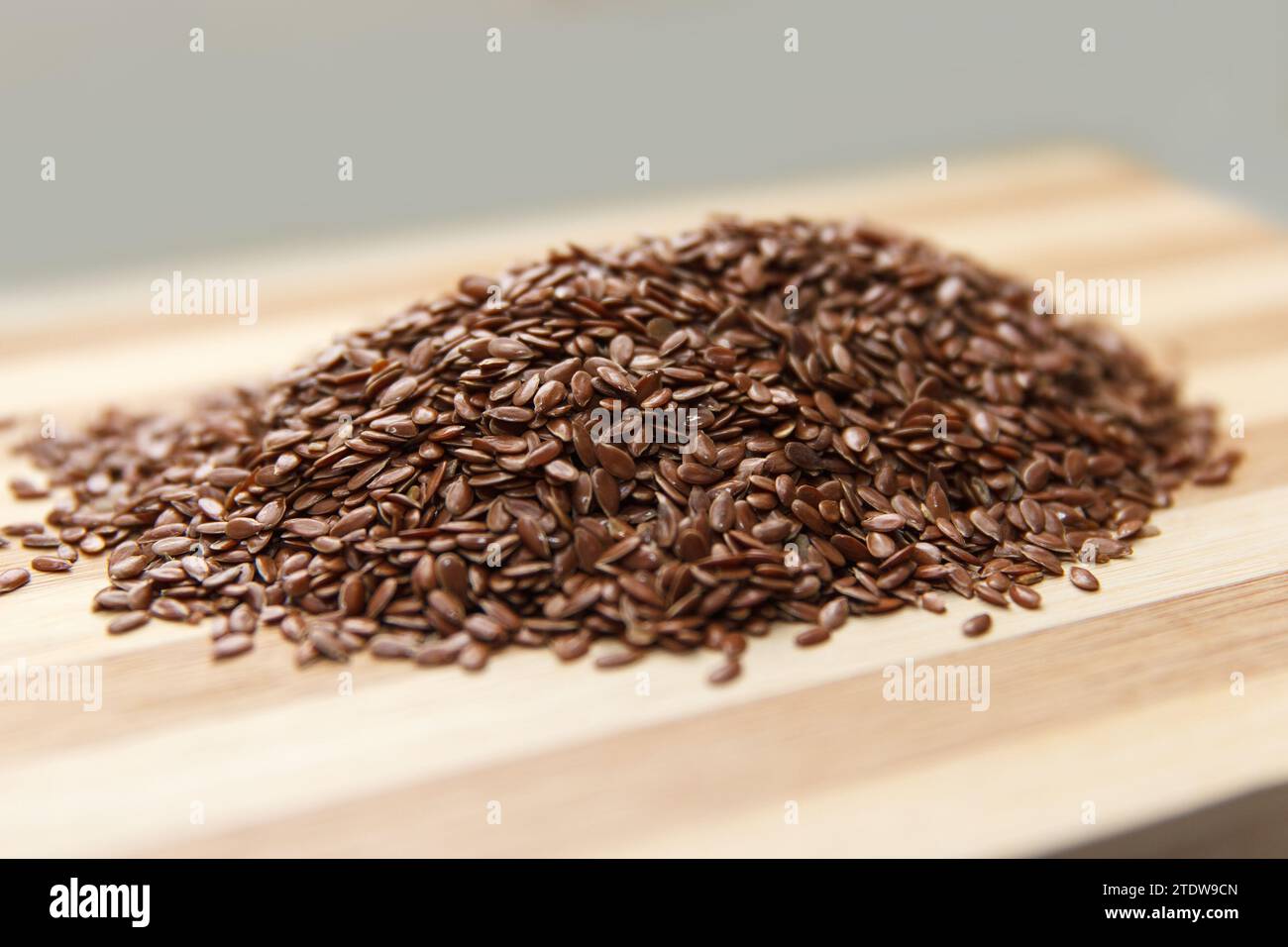 Many linen raw seeds lie on a wooden surface in the kitchen. Side view ...